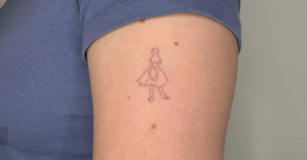 Little fine line style ballerina tattoo located on the