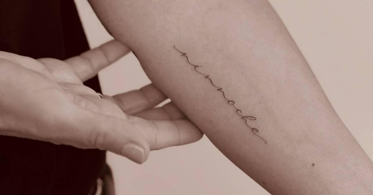 Lettering tattoo in script font located on the inner