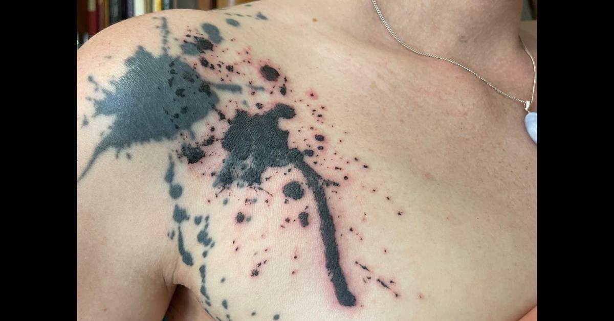 Ink splatter tattoo located on the shoulder, blackwork