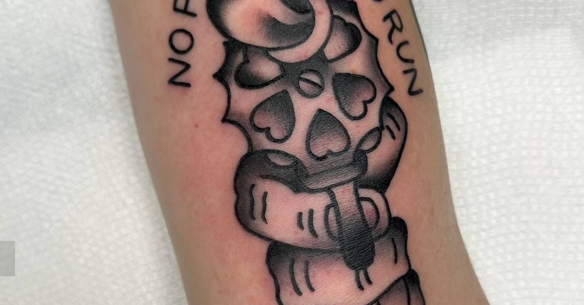 Revolver tattooed on the inner arm, done in traditional