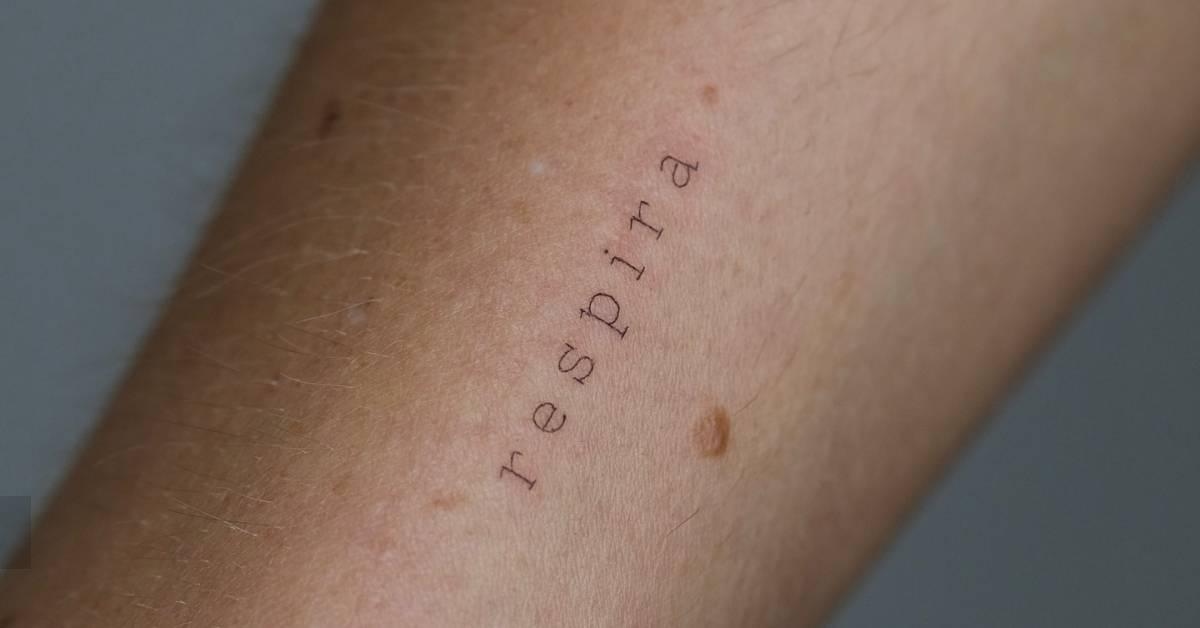 Word "respira" in typewriter font tattooed on the