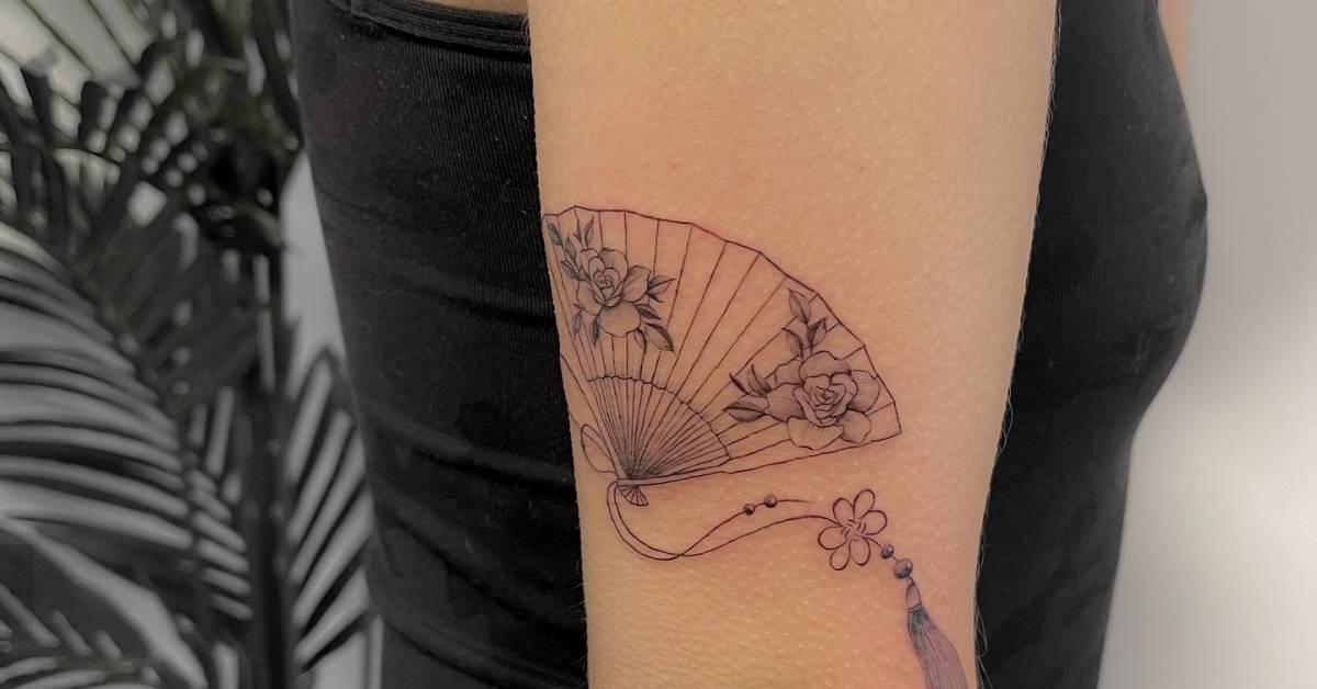 Hand fan tattoo done on the tricep, illustrative style.
