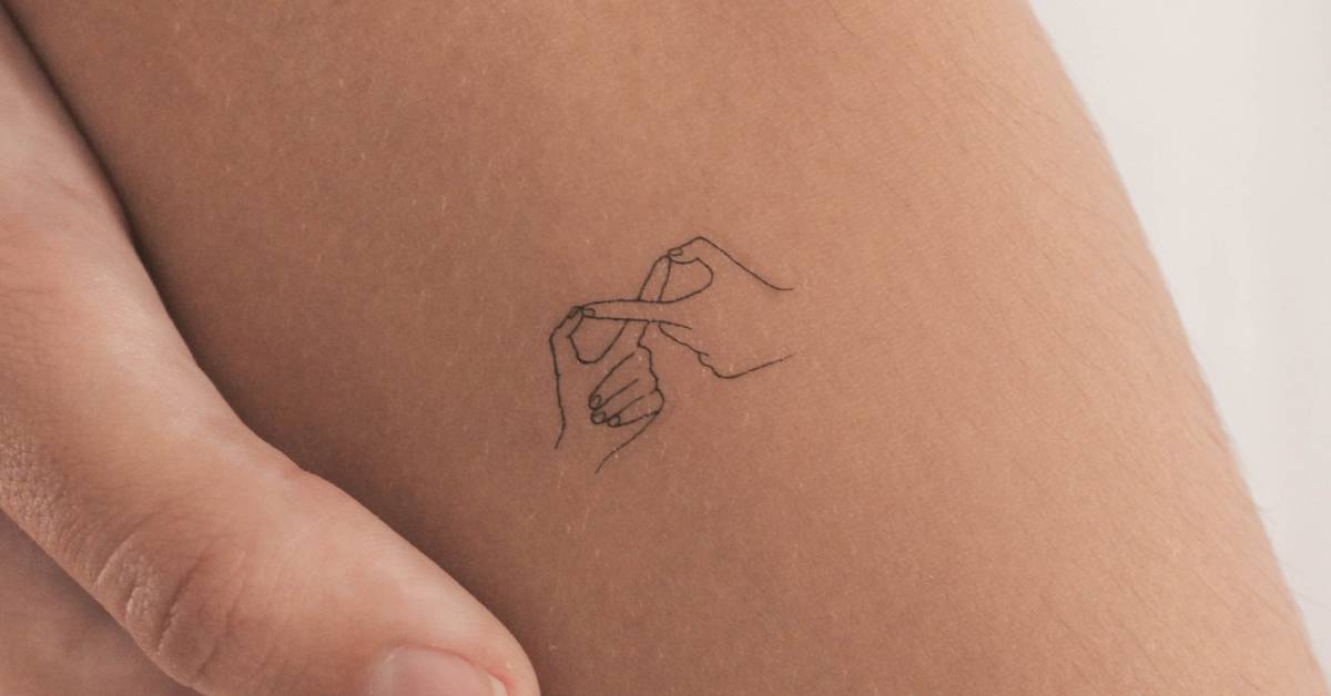 Infinity hand gesture temporary tattoo located on the