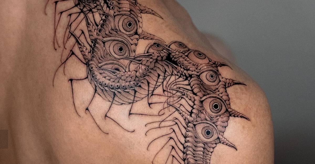 Eye centipede tattoo located on the top of shoulder,