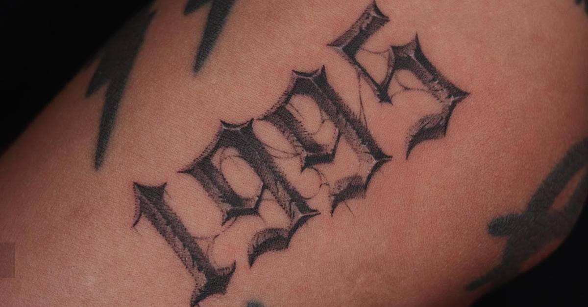 Gothic font "1995" lettering tattoo located on the