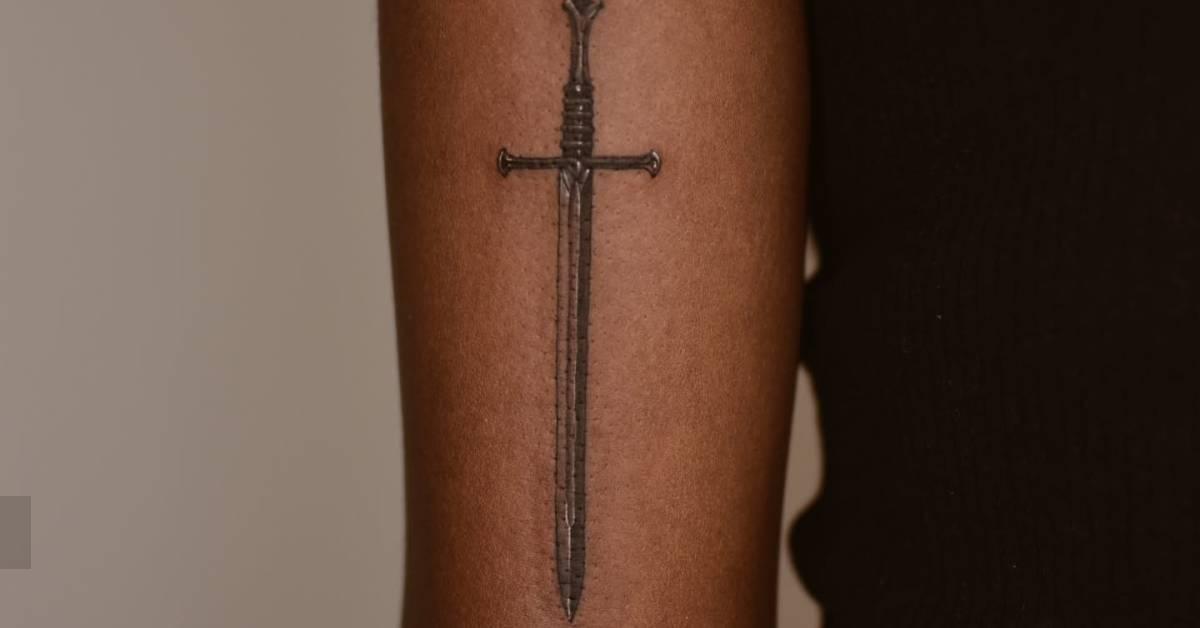 Micro-realistic style sword tattoo located on the