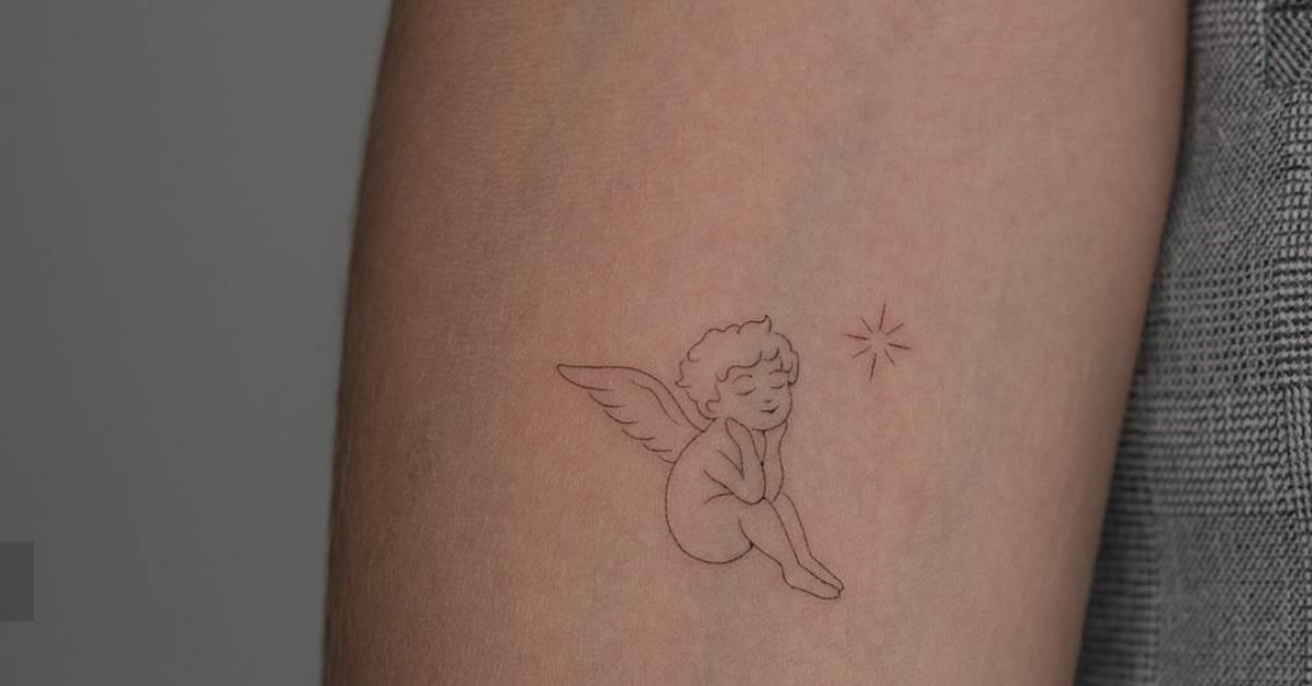 Fine line style cherub tattoo located on the inner