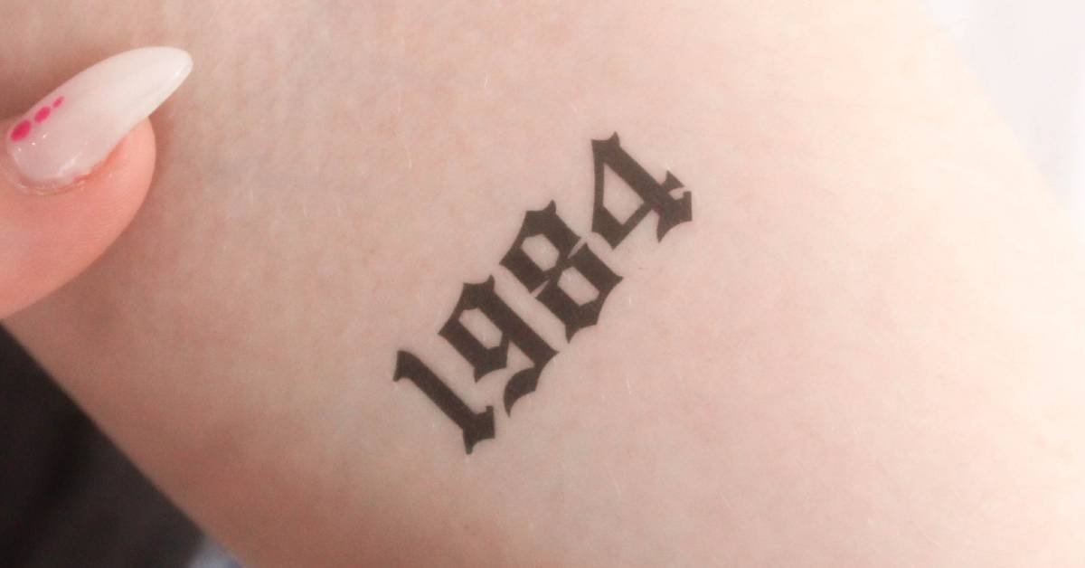 Gothic font "1984" temporary lettering tattoo located