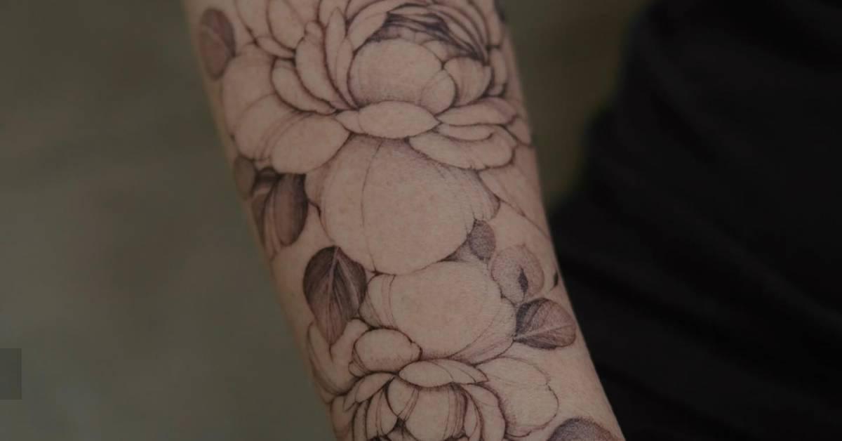 Illustrative style peonies tattooed on the forearm.