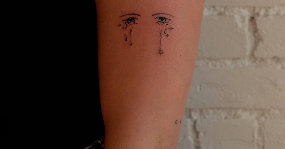 Crying eyes tattoo in illustrative style located on the