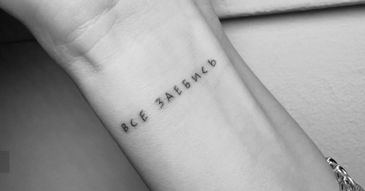 Russian quote tattoo located on the wrist.
