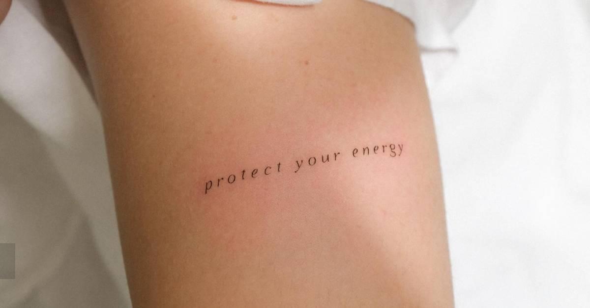 "Protect your energy" lettering tattoo located on the