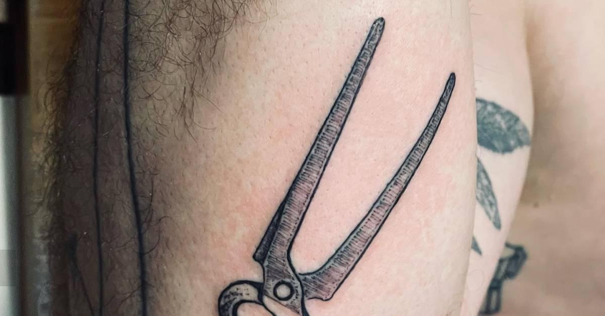 Engraving style pincer tattoo located on the forearm.