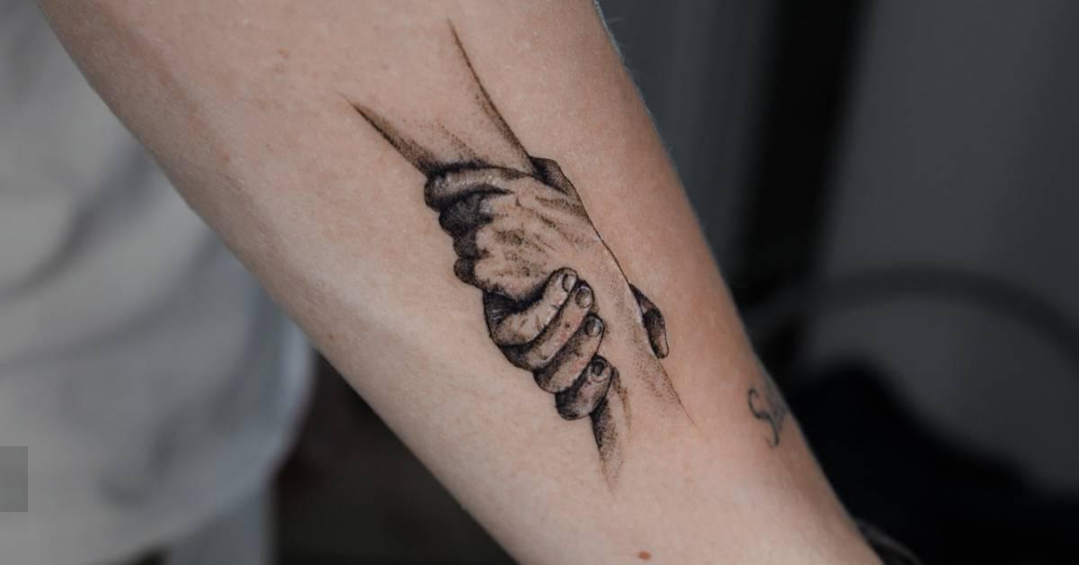 Holding hands tattoo located on the forearm,