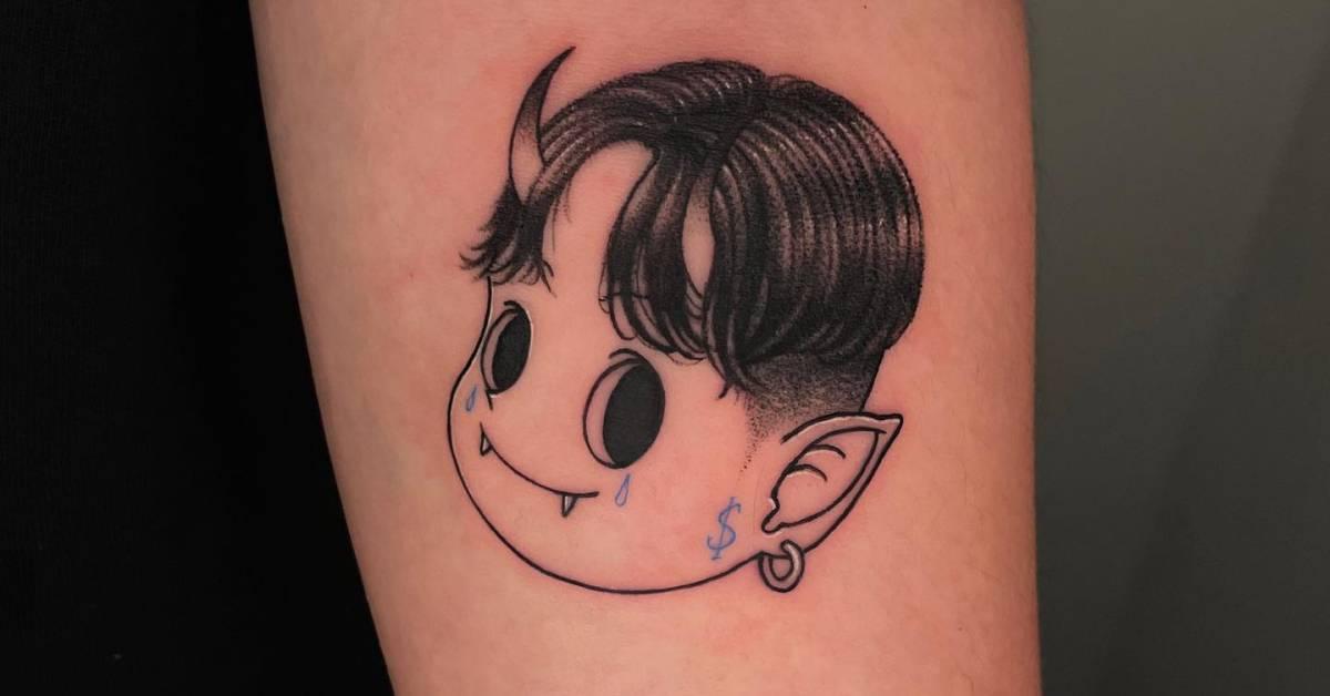 Cartoon style cute devil portrait tattoo located on the