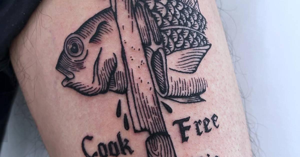 Chef knife and fish tattoo located on the thigh,