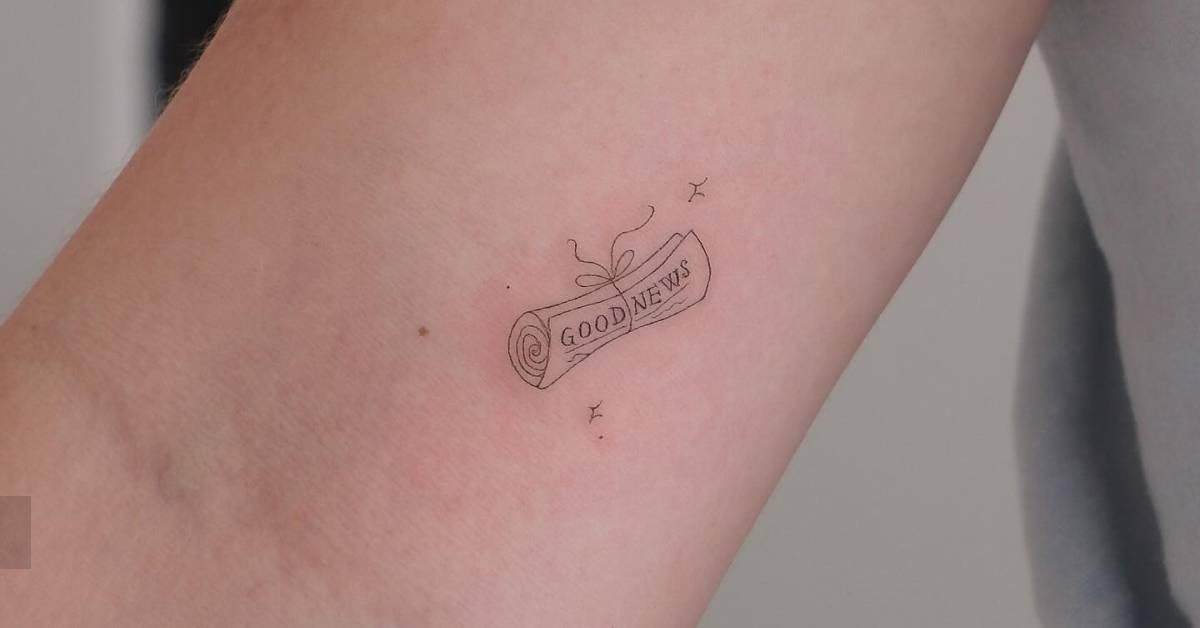 Cute newspaper tattoo in fine line style located on the