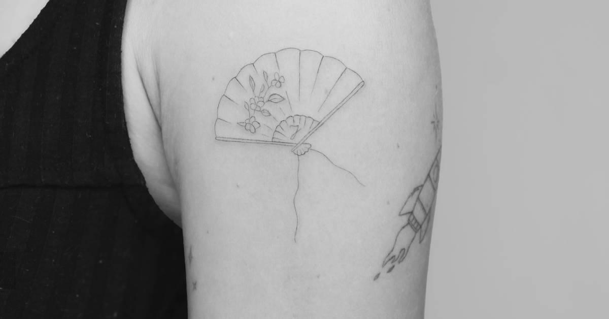 Hand fan tattoo in fine line style located on the upper