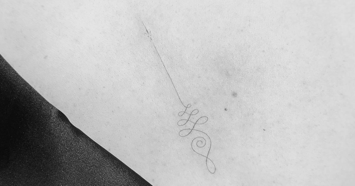 Unalome tattoo done on the upper back, fine line style.