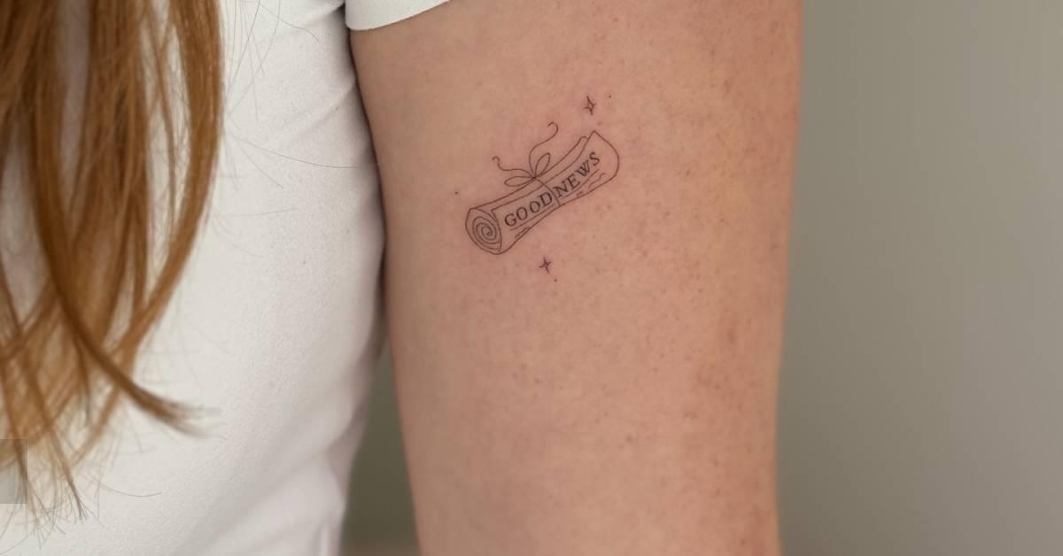 Fine line style newspaper tattoo done on the upper arm.