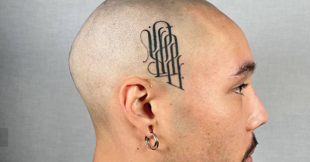 Monogram tattoo located on the side of the head.
