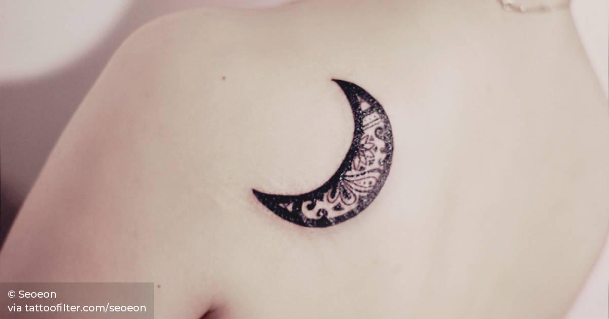 Ornamental moon tattoo on the left shoulder blade.