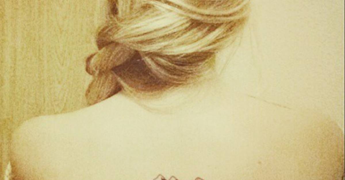 Little upper back tattoo of a mountain range on Lu.