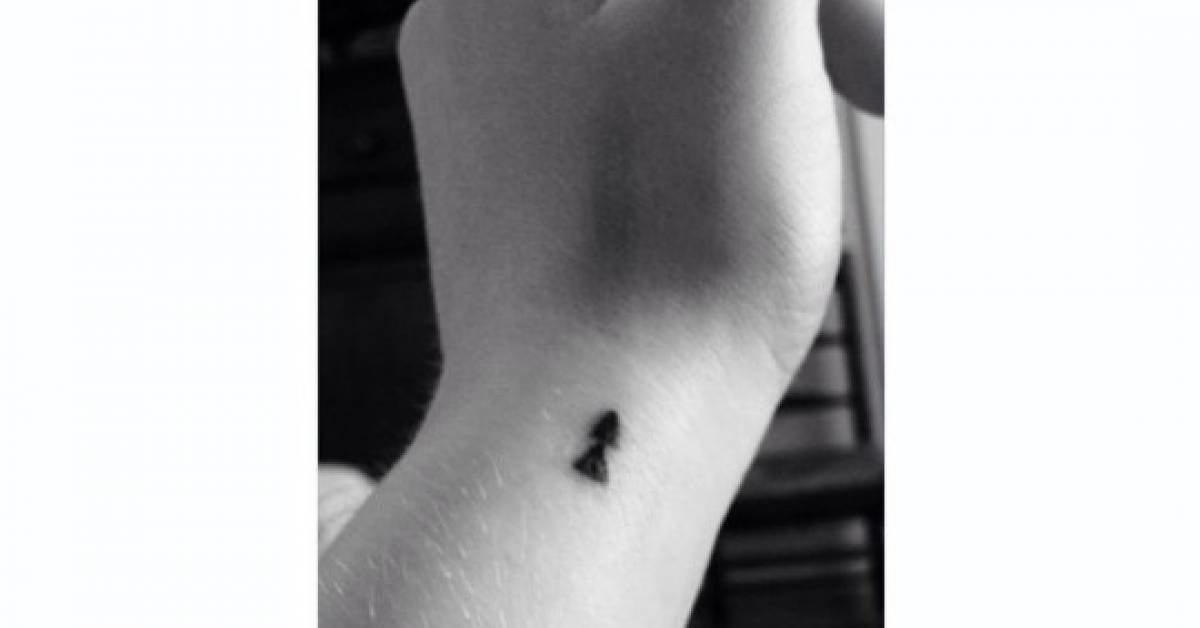 "Fast forward" button tattoo on Kiana.