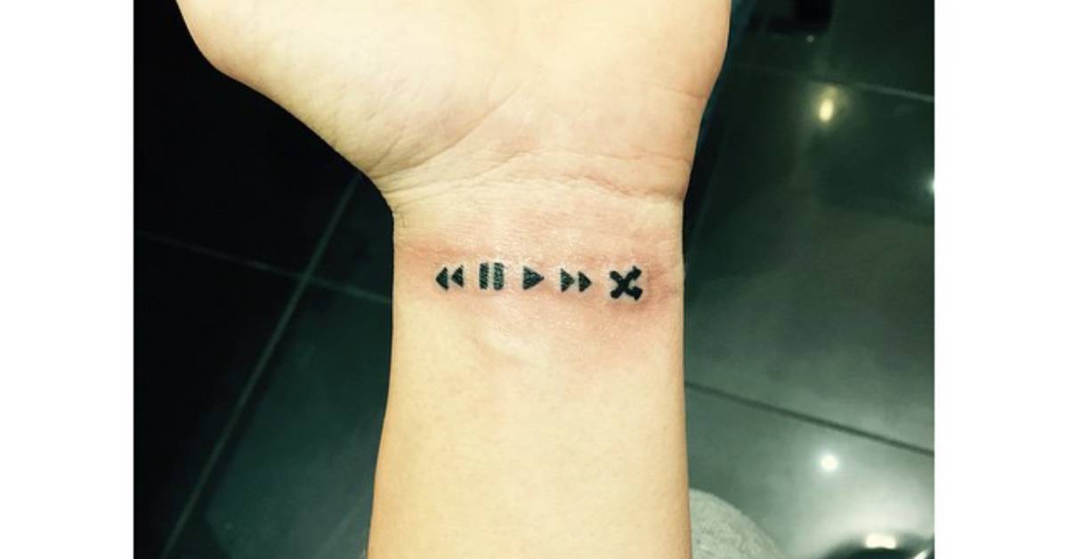 Wrist tattoo of media controls on Luc.