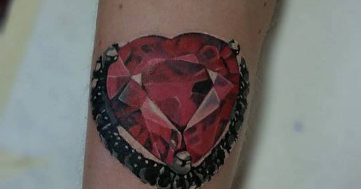 Realistic ruby stone tattoo on the right forearm.