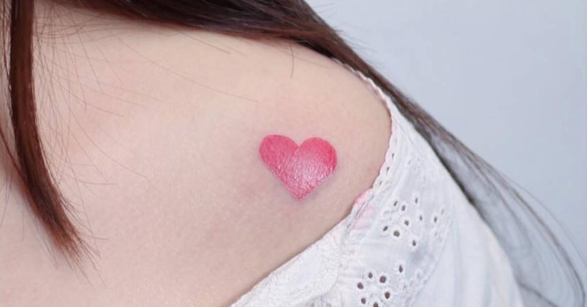 Small heart tattoo on the left shoulder.