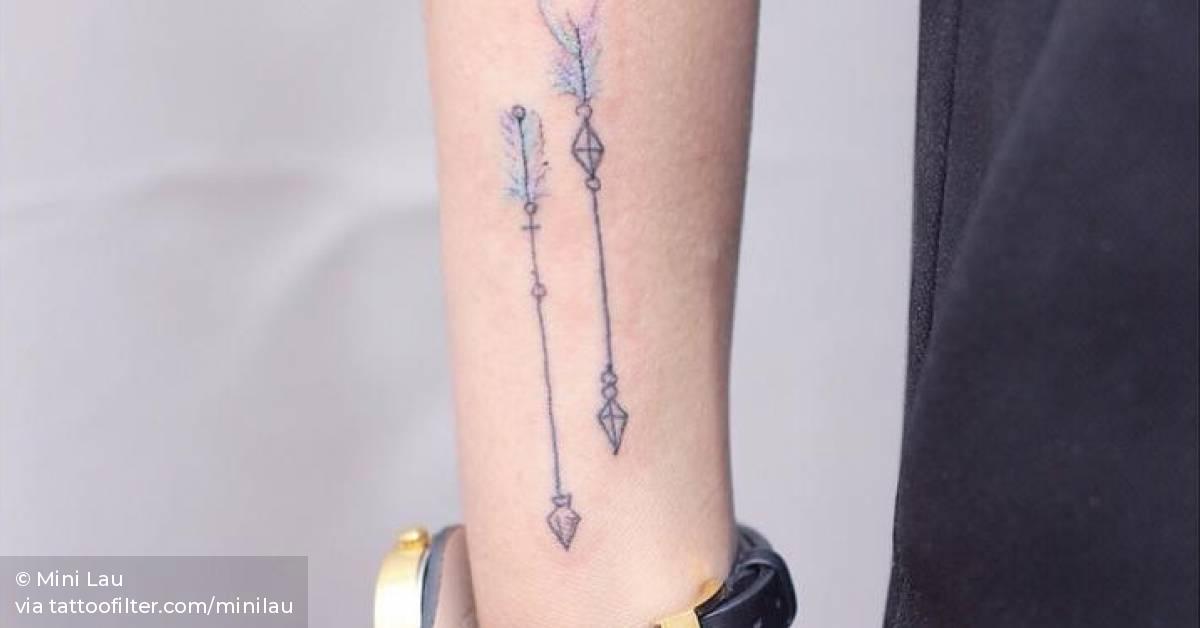 Two arrow tattoos on the right wrist.