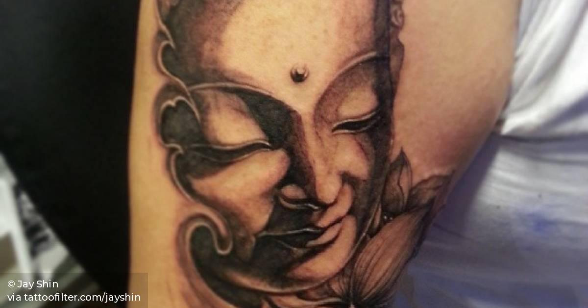 Upper arm tattoo of Buddha by Jay Shin.